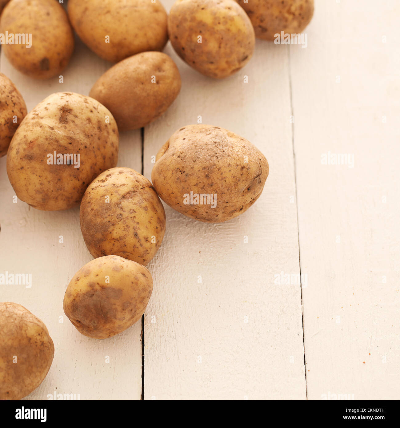 Rustic unpeeled potatoes on a table Stock Photo - Alamy