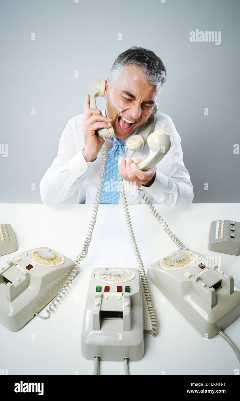 Businessman yelling into phone Stock Photo - Alamy