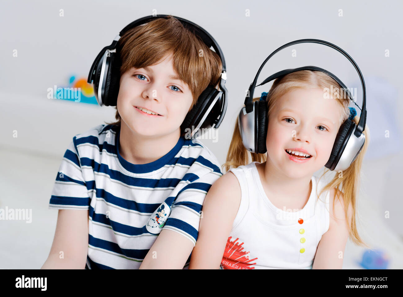 Brother and sister listening music with headphones Stock Photo - Alamy