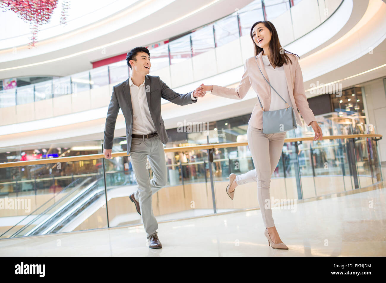 Young couple walking in shopping mall Stock Photo - Alamy