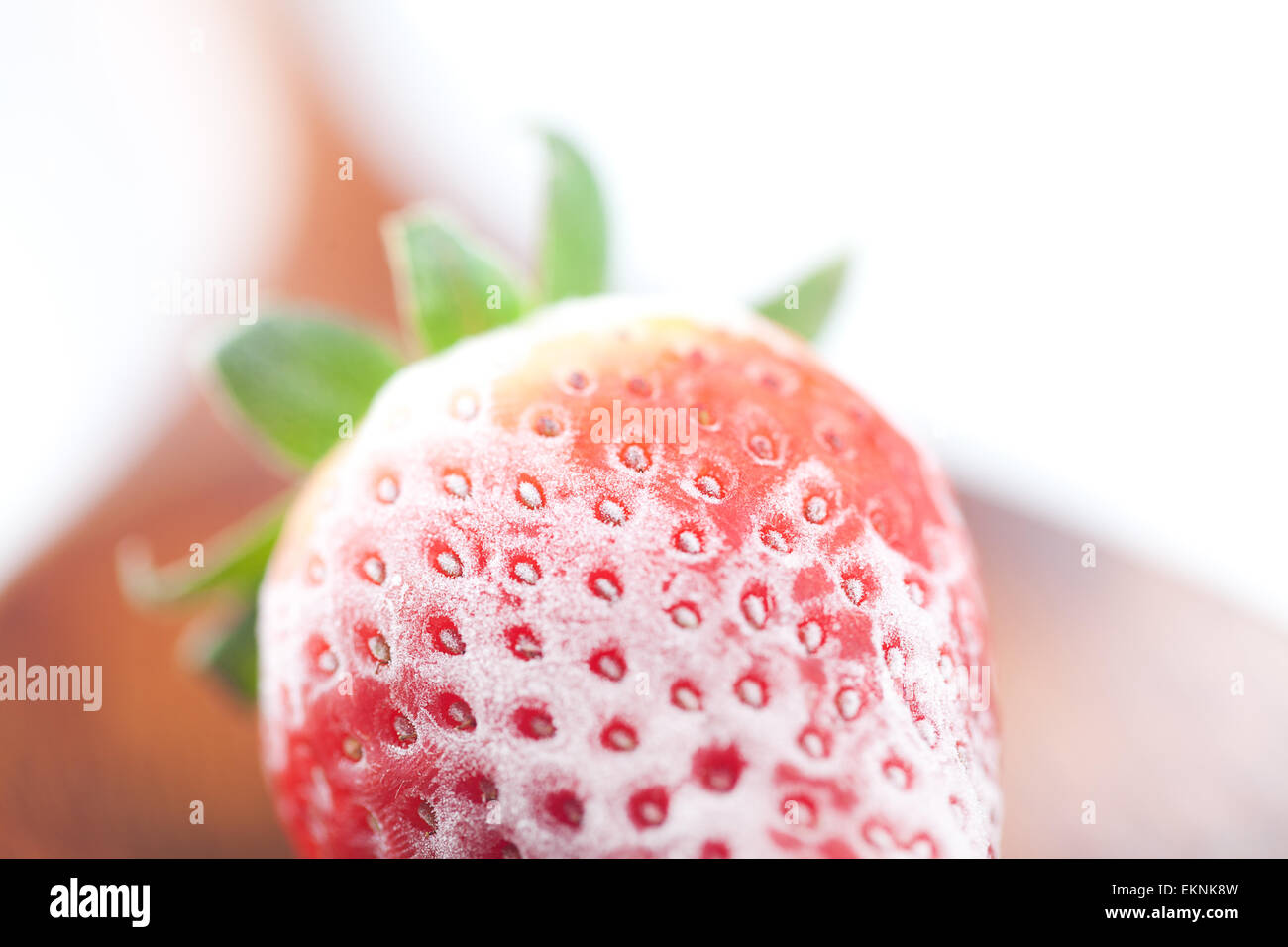 big red strawberry in frost in wooden spoon isolated on white Stock ...