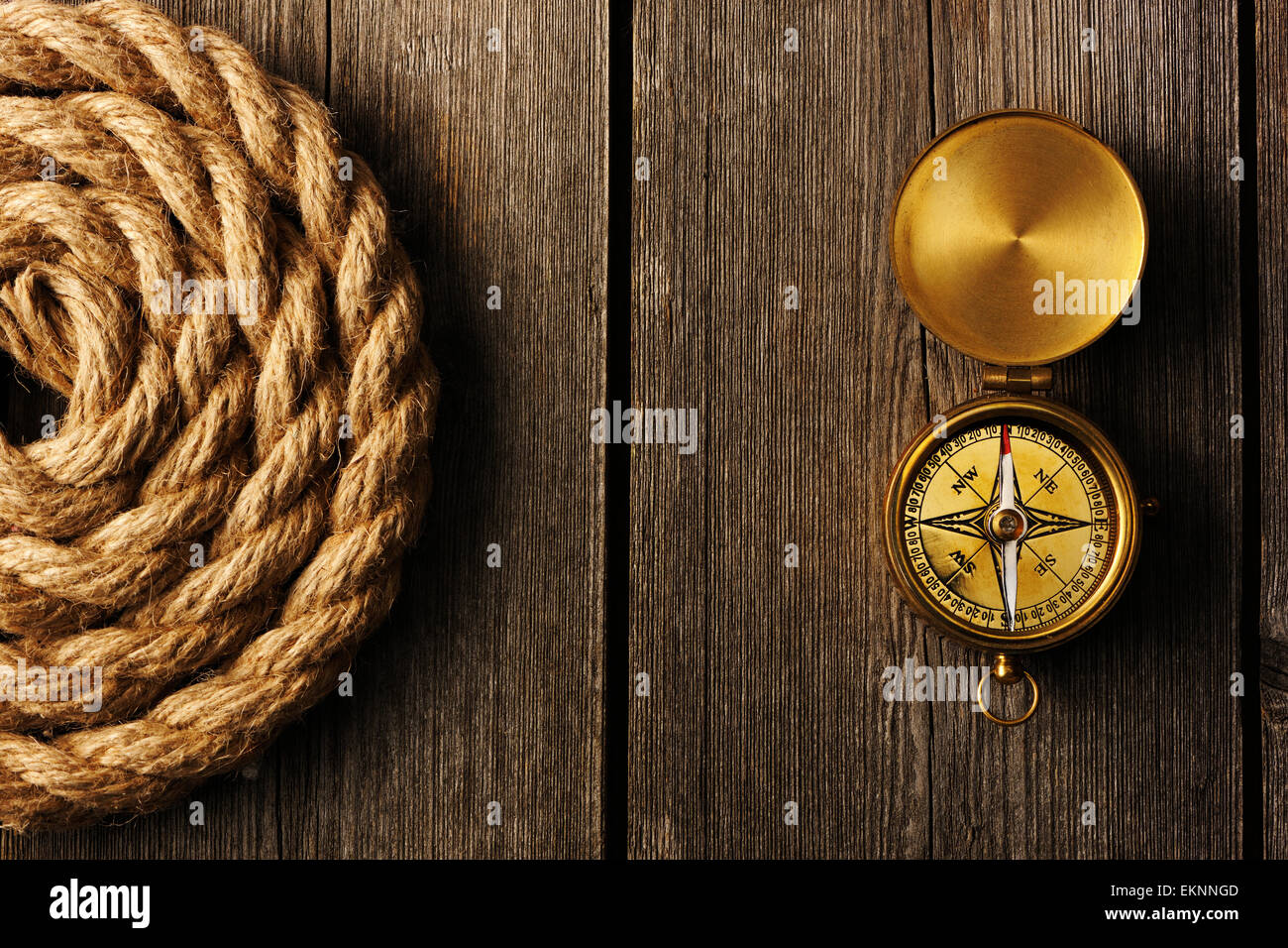 Antique compass and rope over wooden background Stock Photo - Alamy