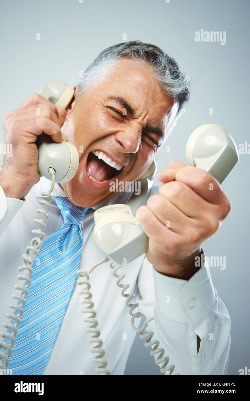 Businessman yelling into phone Stock Photo - Alamy
