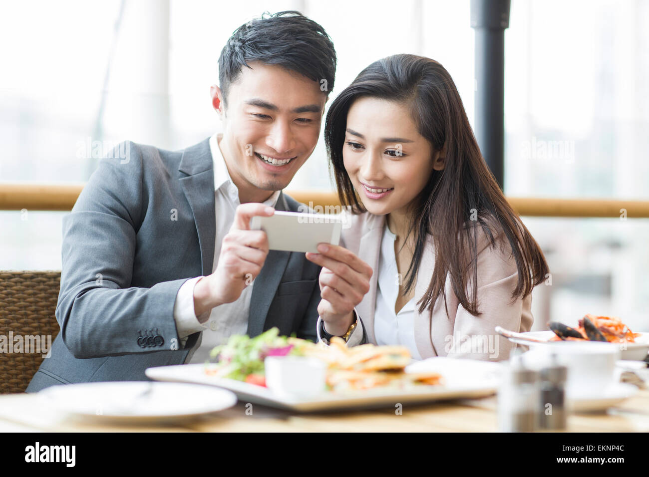 Young couple photographing in restaurant Stock Photo - Alamy