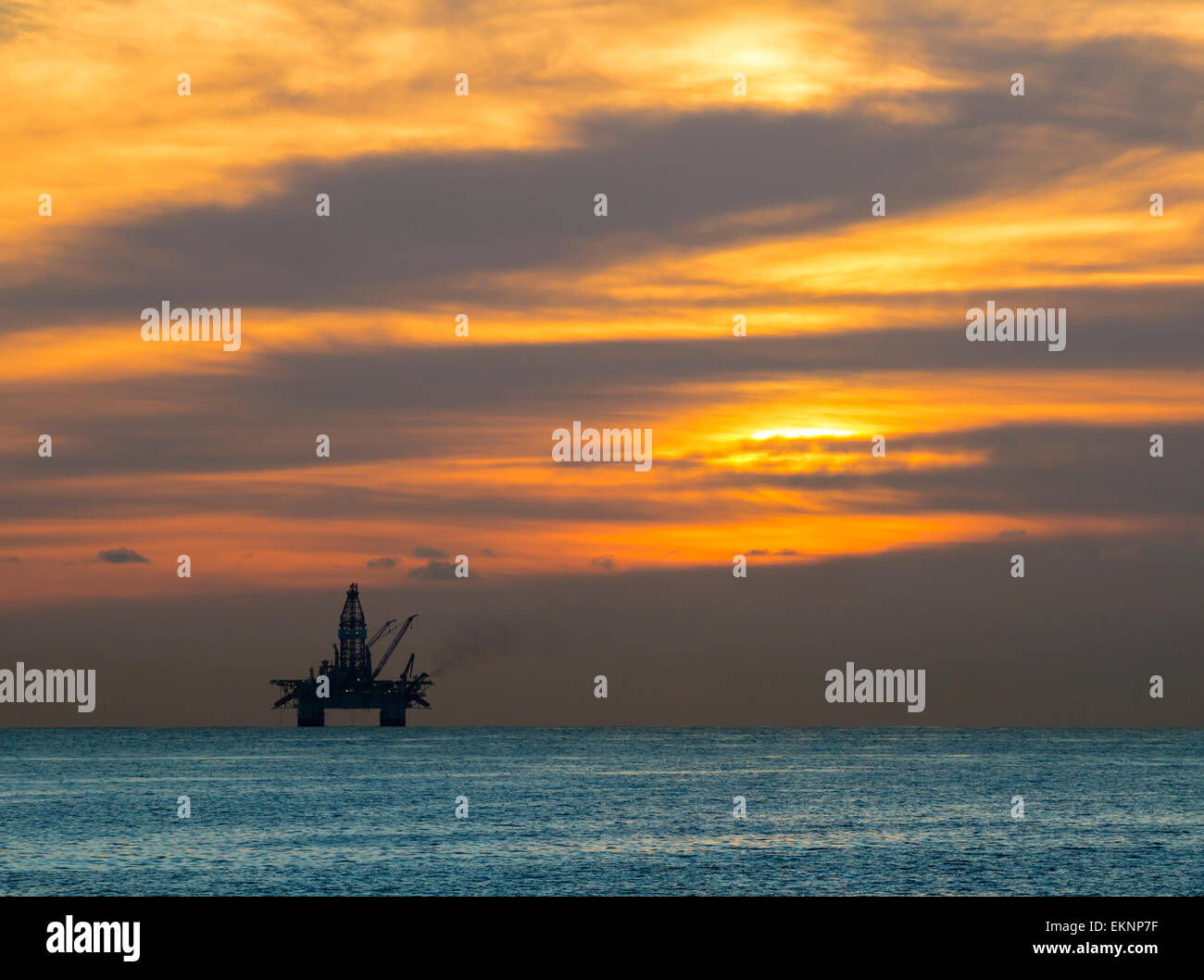 Oil rig at sunrise Stock Photo - Alamy