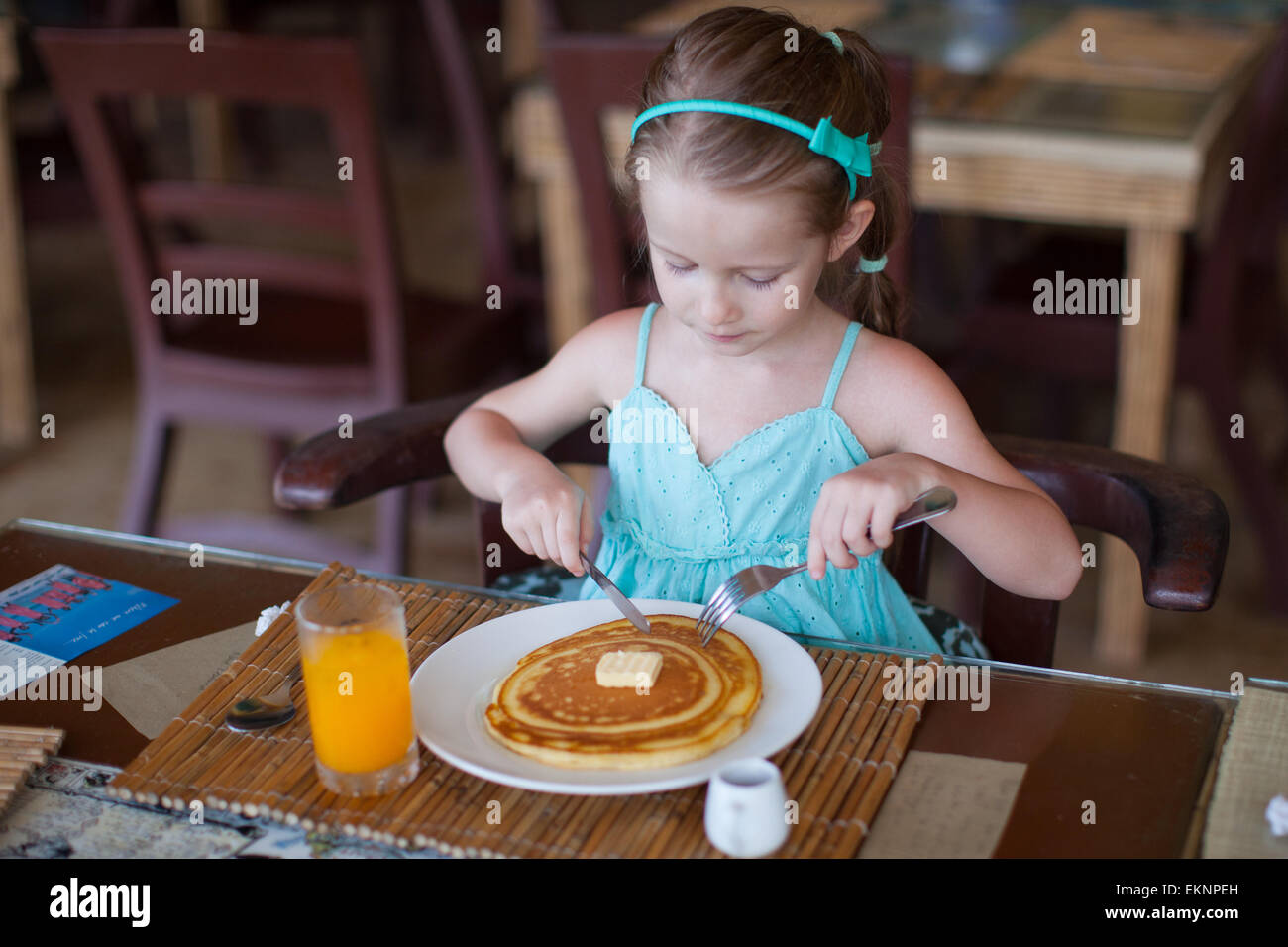 Adorable little girl having breakfast at resort restaurant Stock Photo ...