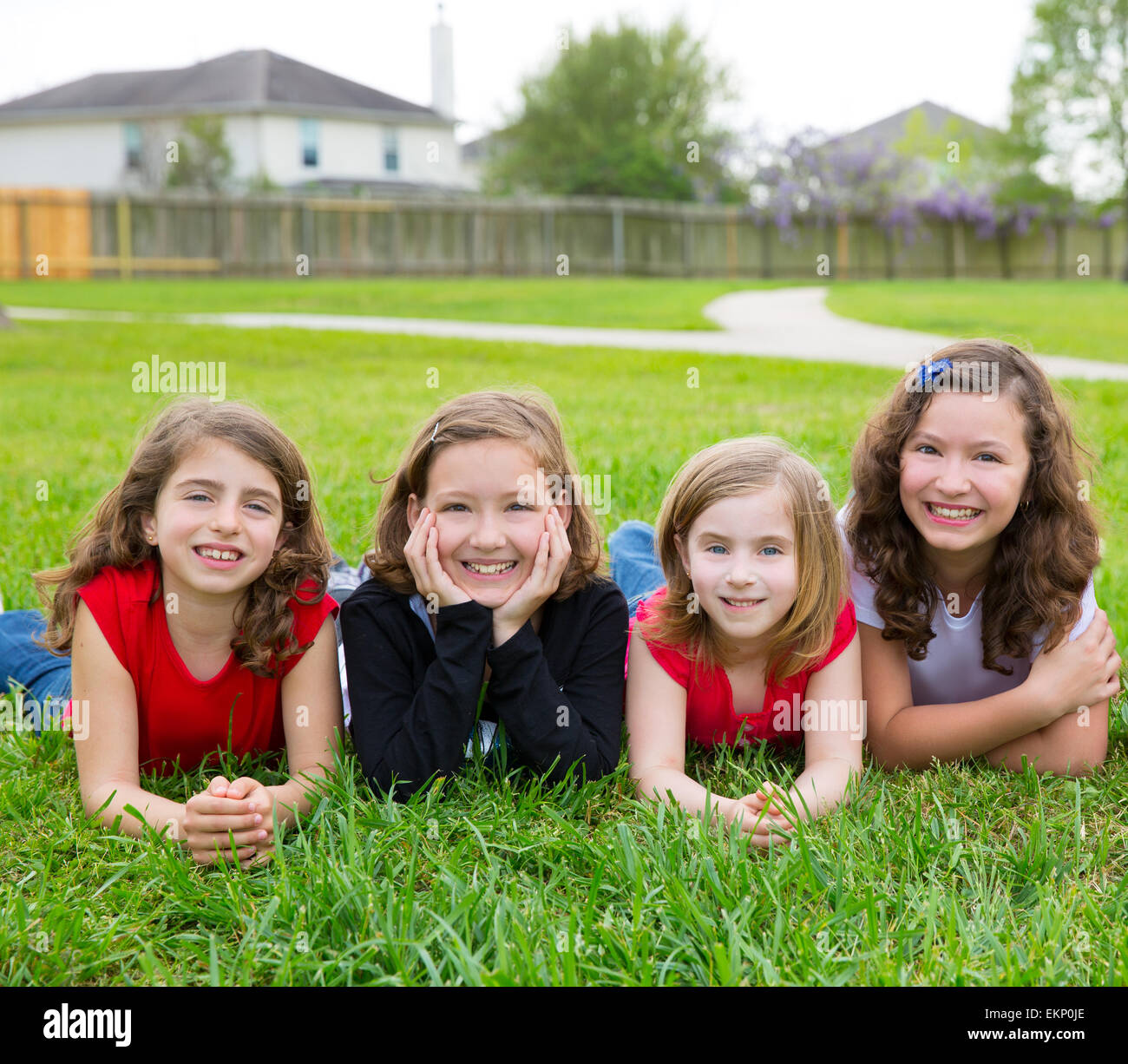 Children girls group lying on lawn grass smiling happy Stock Photo - Alamy