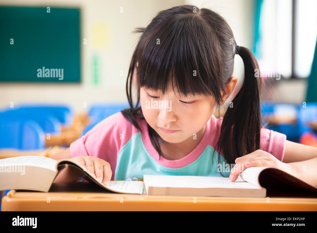 little girl study alone in the classroom Stock Photo - Alamy