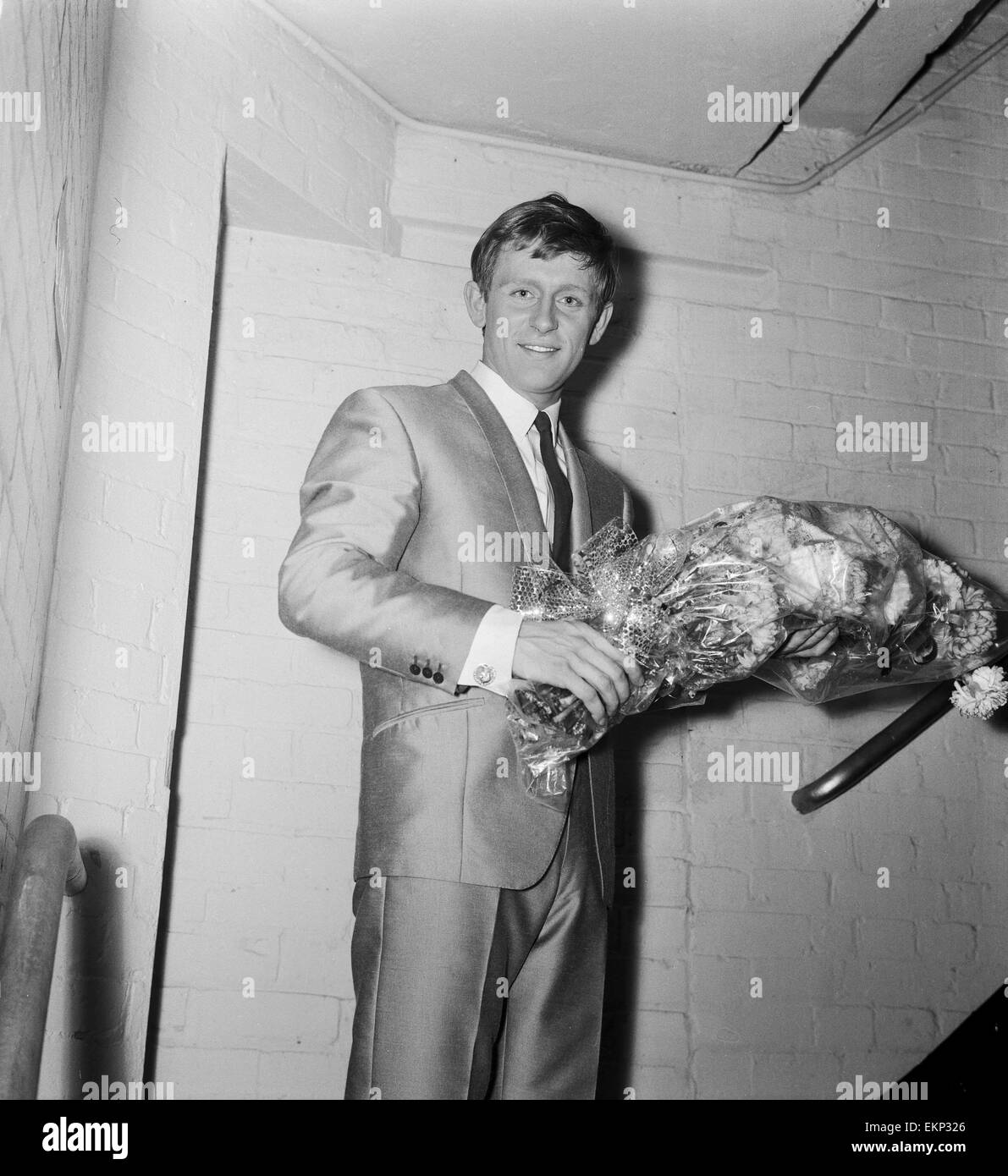 Singer Johnny Leyton holding a bunch of flowers backstage after giving ...