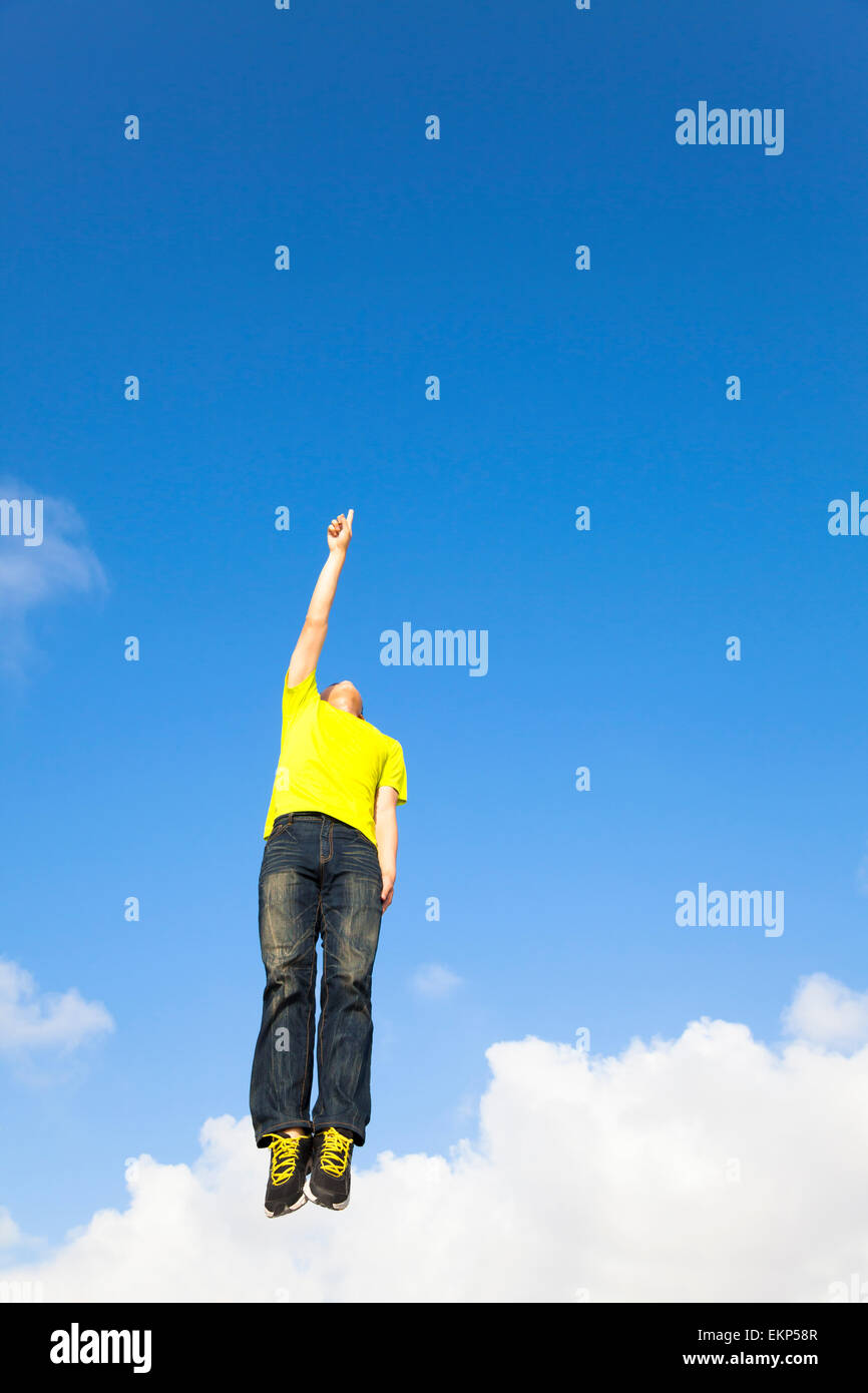 relaxed young man jumping and pointing sky Stock Photo - Alamy