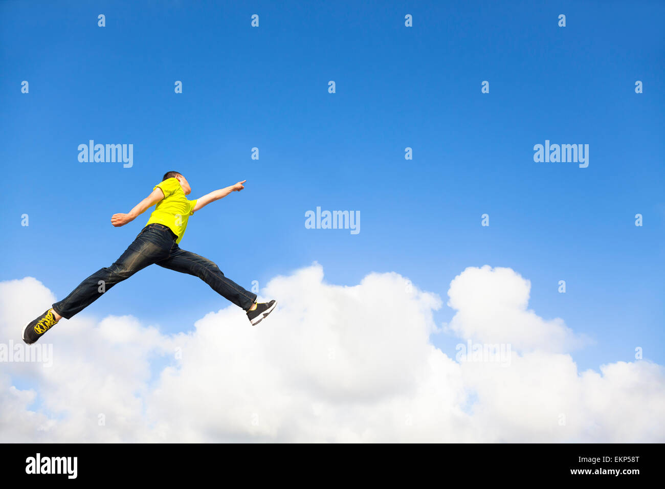 happy young man jumping and pointing to sky Stock Photo - Alamy