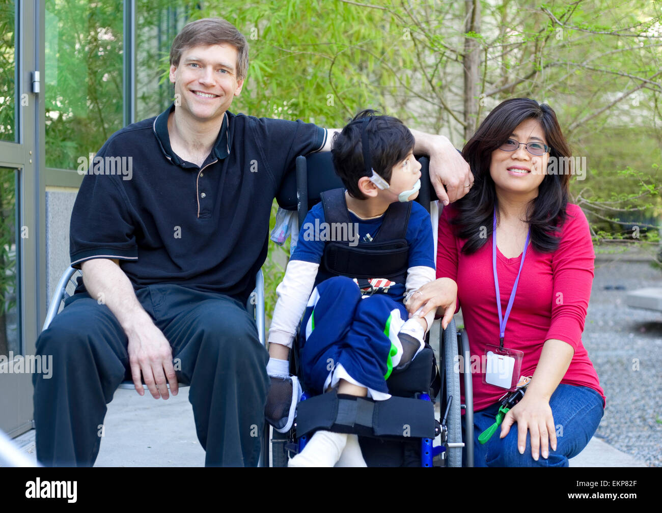 Disabled child in wheelchair with his parents Stock Photo - Alamy