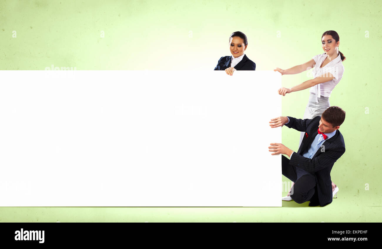 Three young people holding banner Stock Photo - Alamy