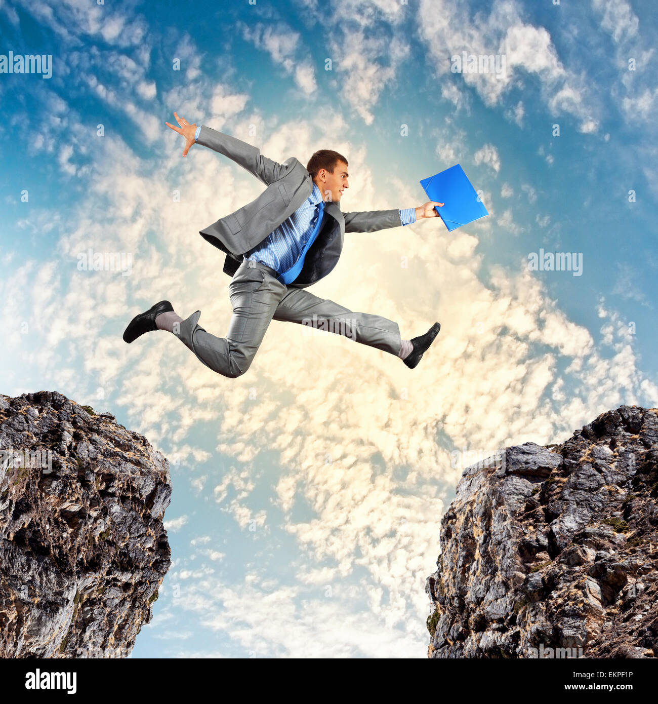 Businessman jumping over gap Stock Photo - Alamy