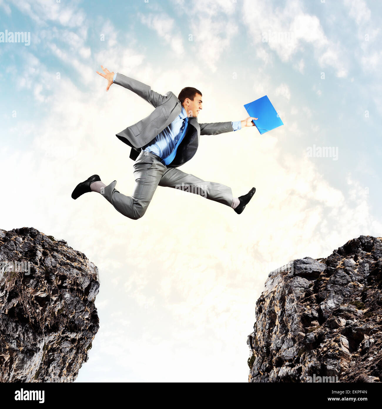Businessman jumping over gap Stock Photo - Alamy