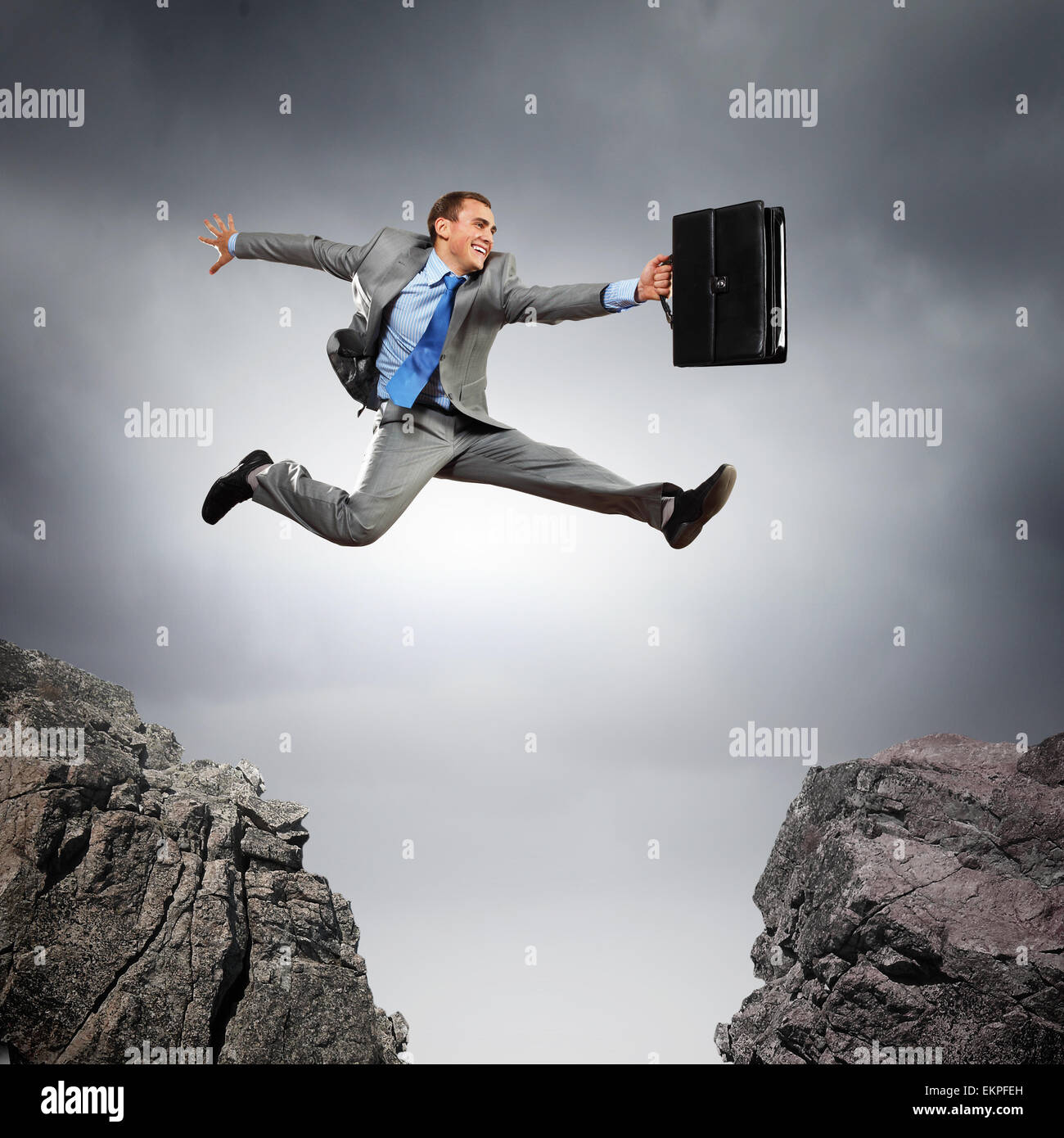 Businessman jumping over gap Stock Photo - Alamy