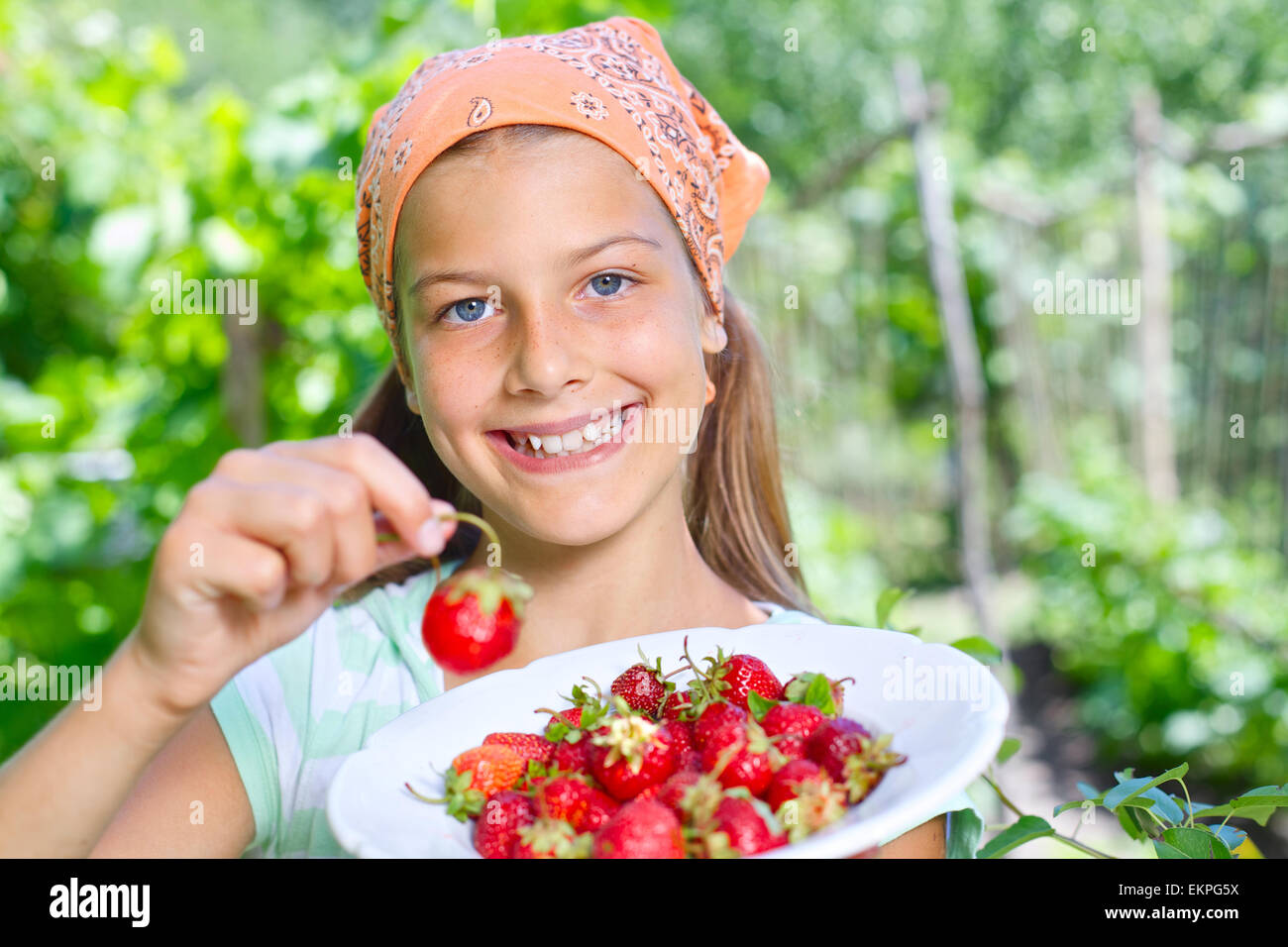 Girl eating strawberries Stock Photo - Alamy