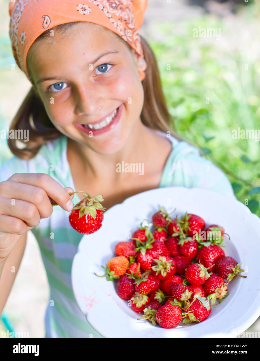 Girl eating strawberries Stock Photo - Alamy