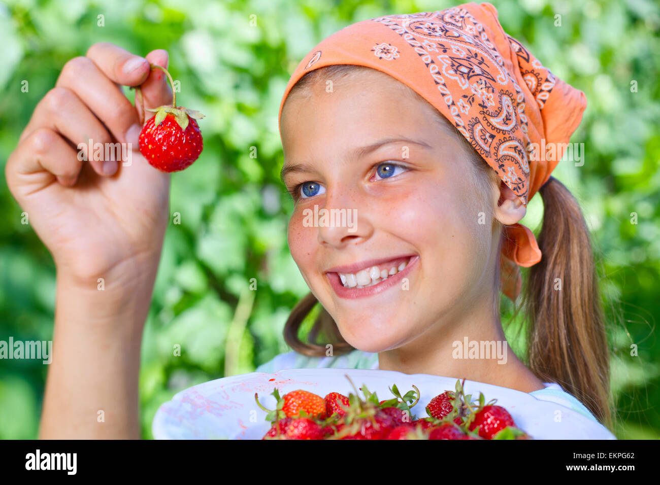 Girl eating strawberries Stock Photo - Alamy