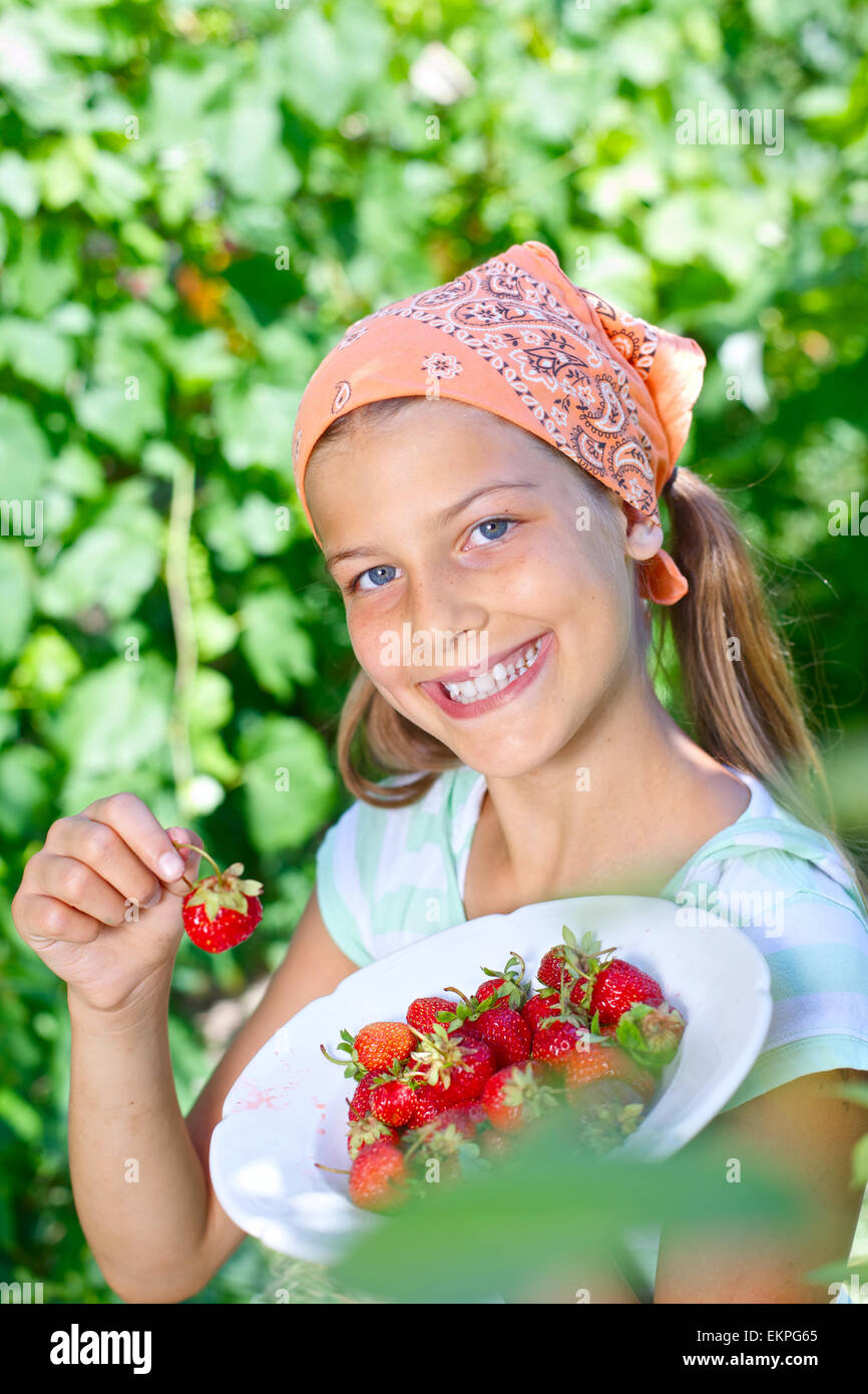 Girl eating strawberries Stock Photo - Alamy