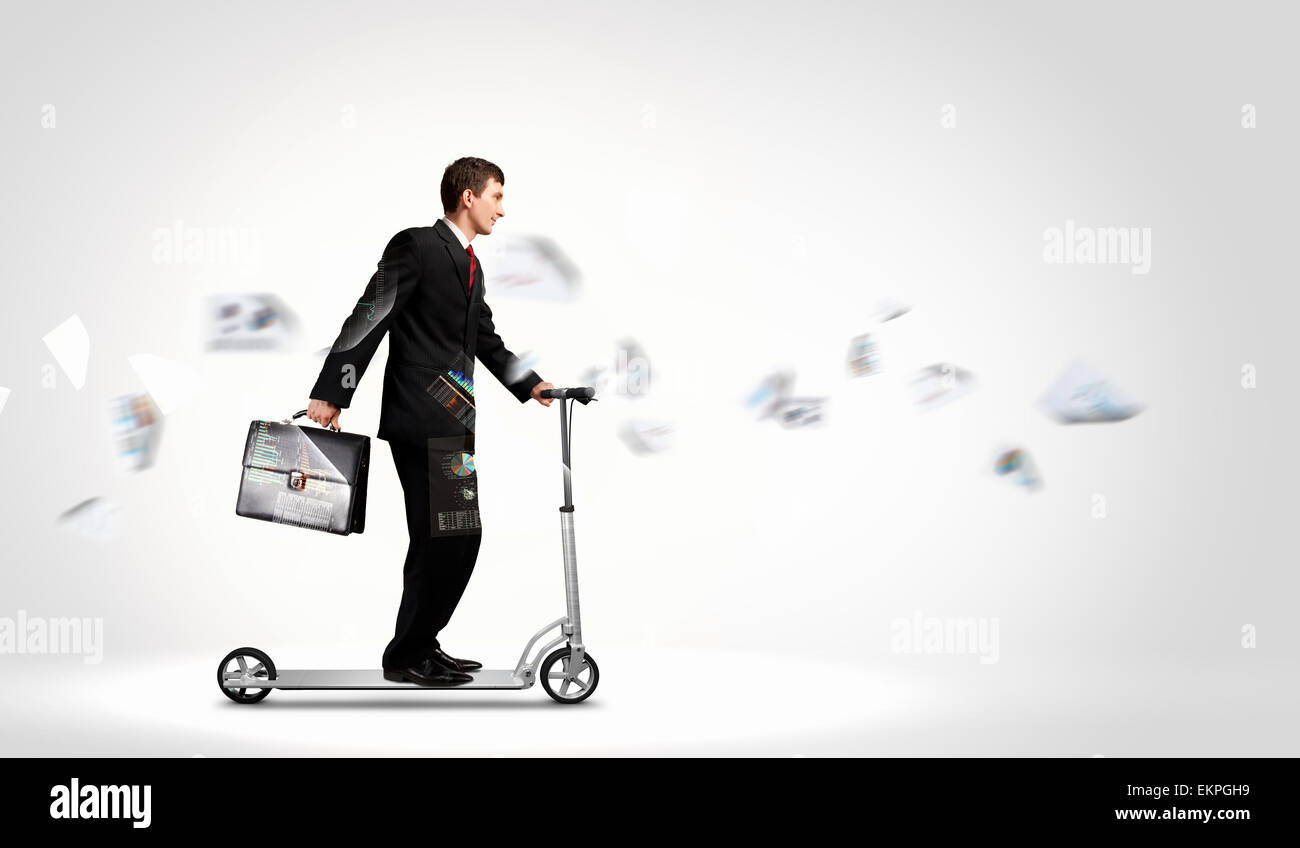 Businessman riding scooter Stock Photo - Alamy