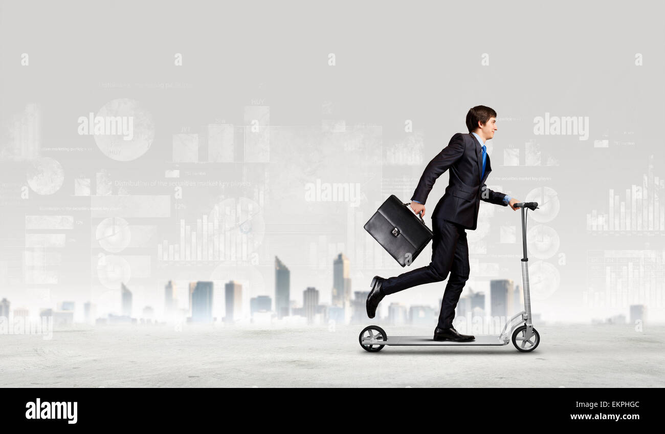 Businessman riding scooter Stock Photo - Alamy
