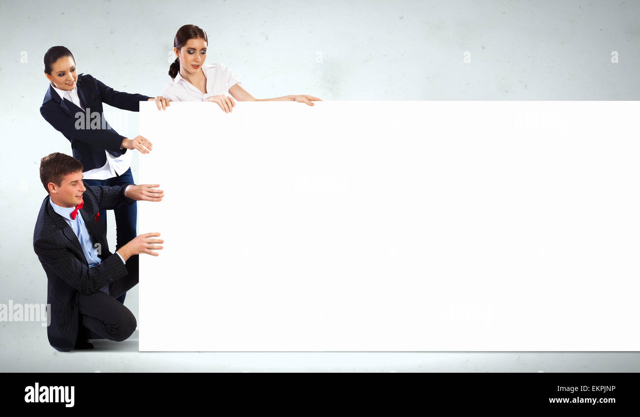 Three young people holding banner Stock Photo - Alamy