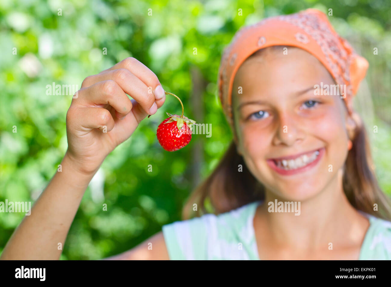 Girl eating strawberries Stock Photo - Alamy