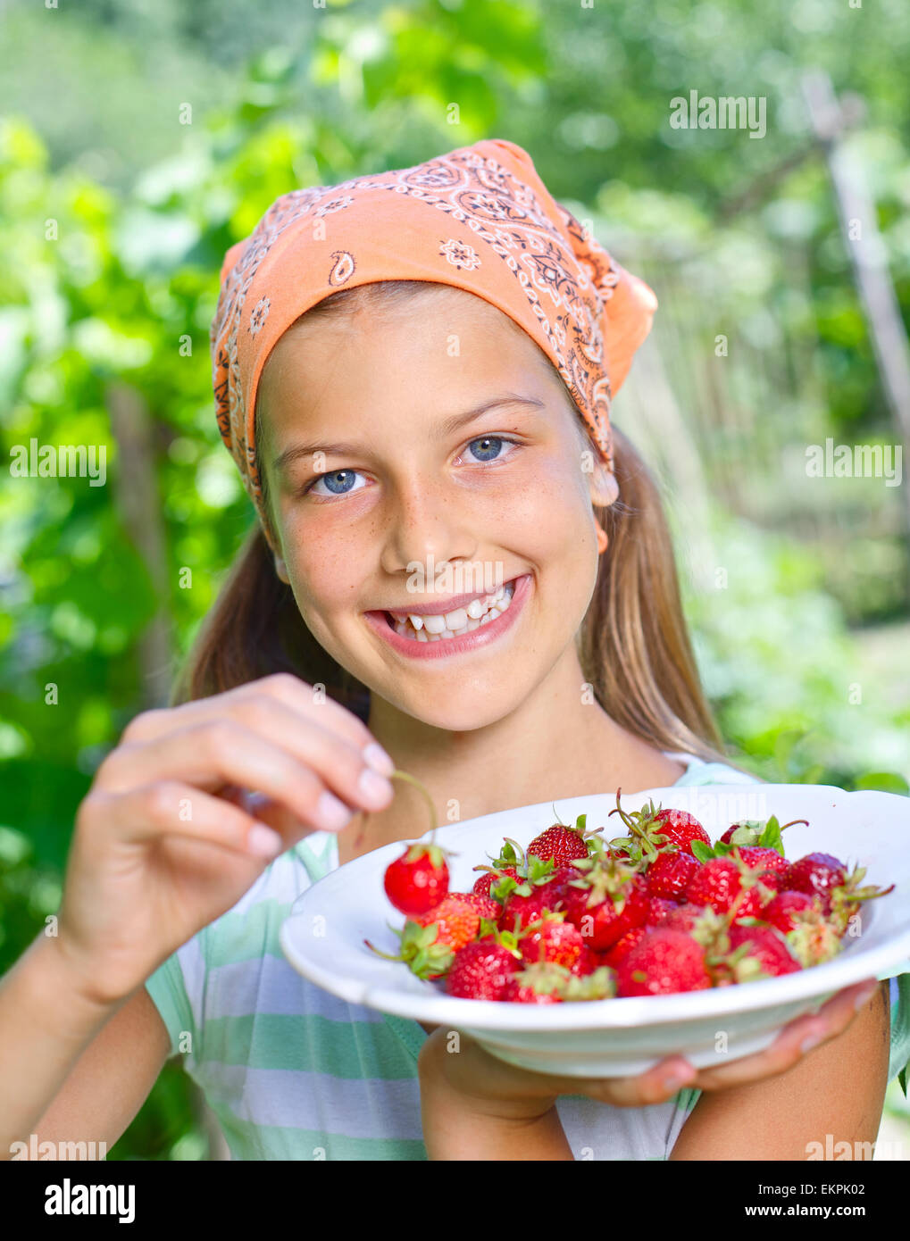 Girl eating strawberries Stock Photo - Alamy