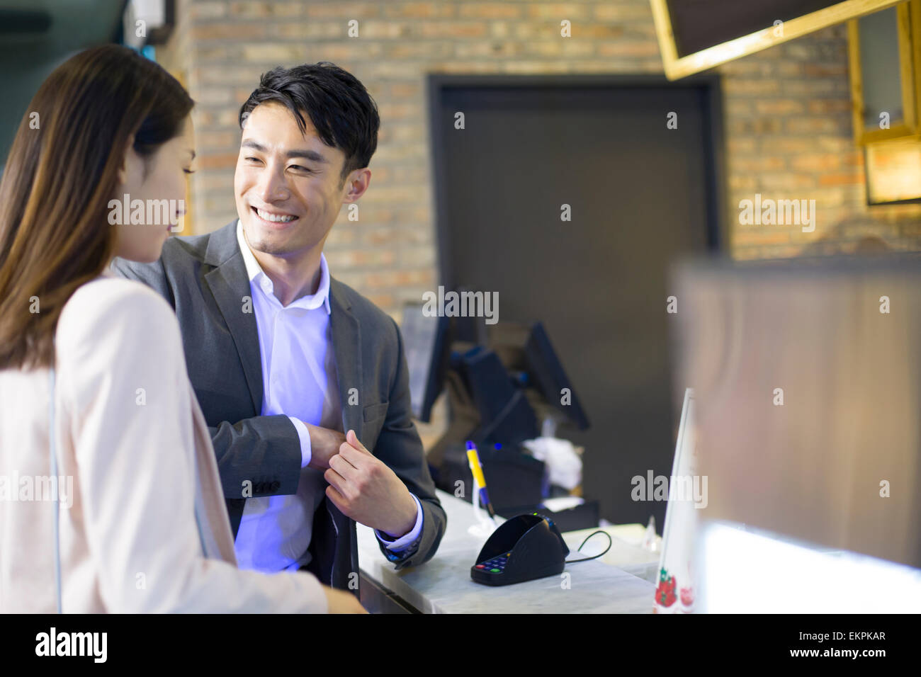 Young couple standing at checkout counter Stock Photo - Alamy