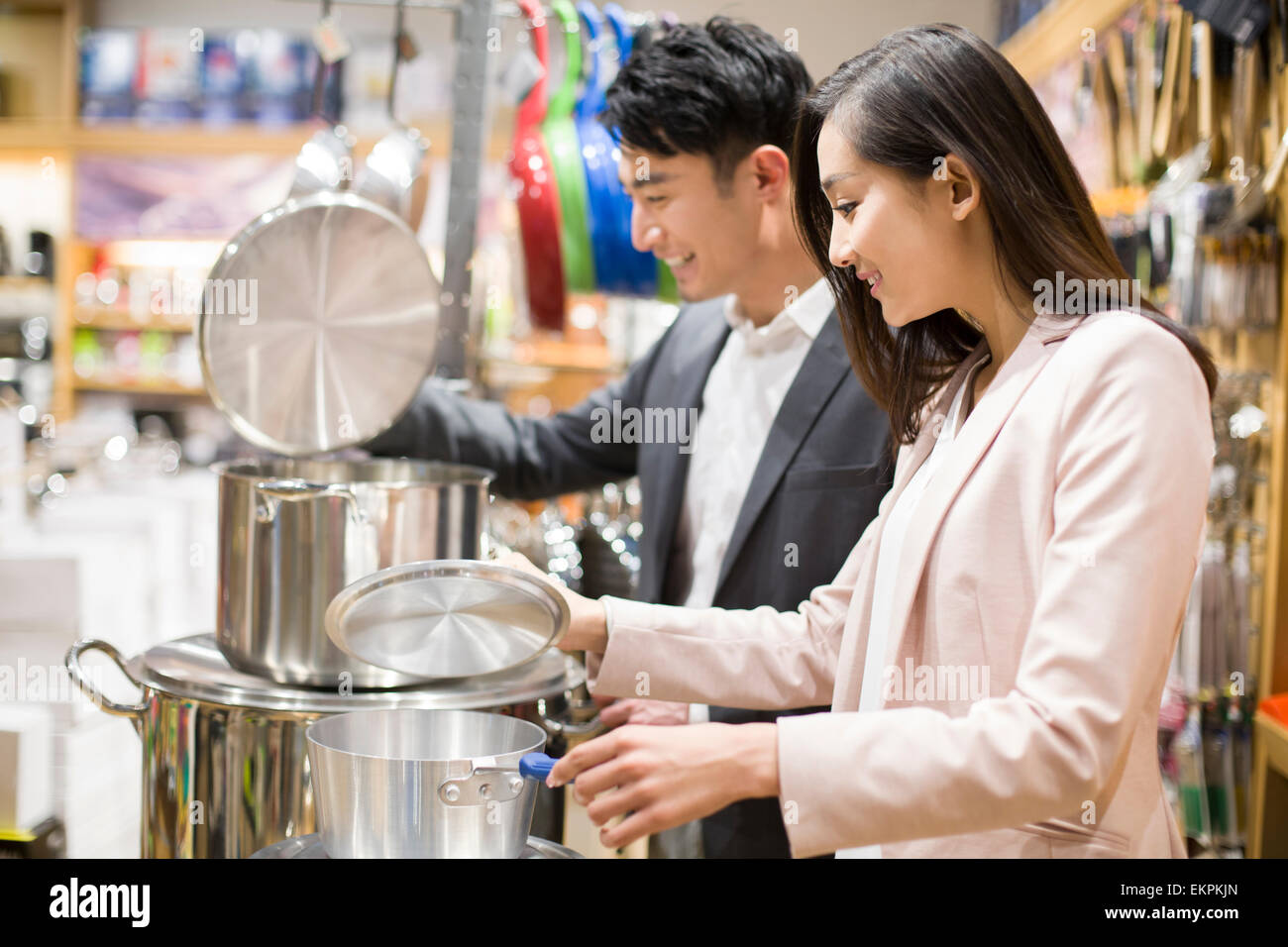 Young couple buying cooking utensil in supermarket Stock Photo - Alamy