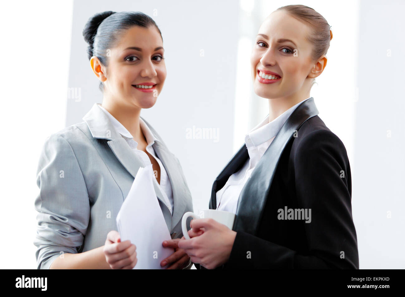 Two attractive business women smiling Stock Photo - Alamy
