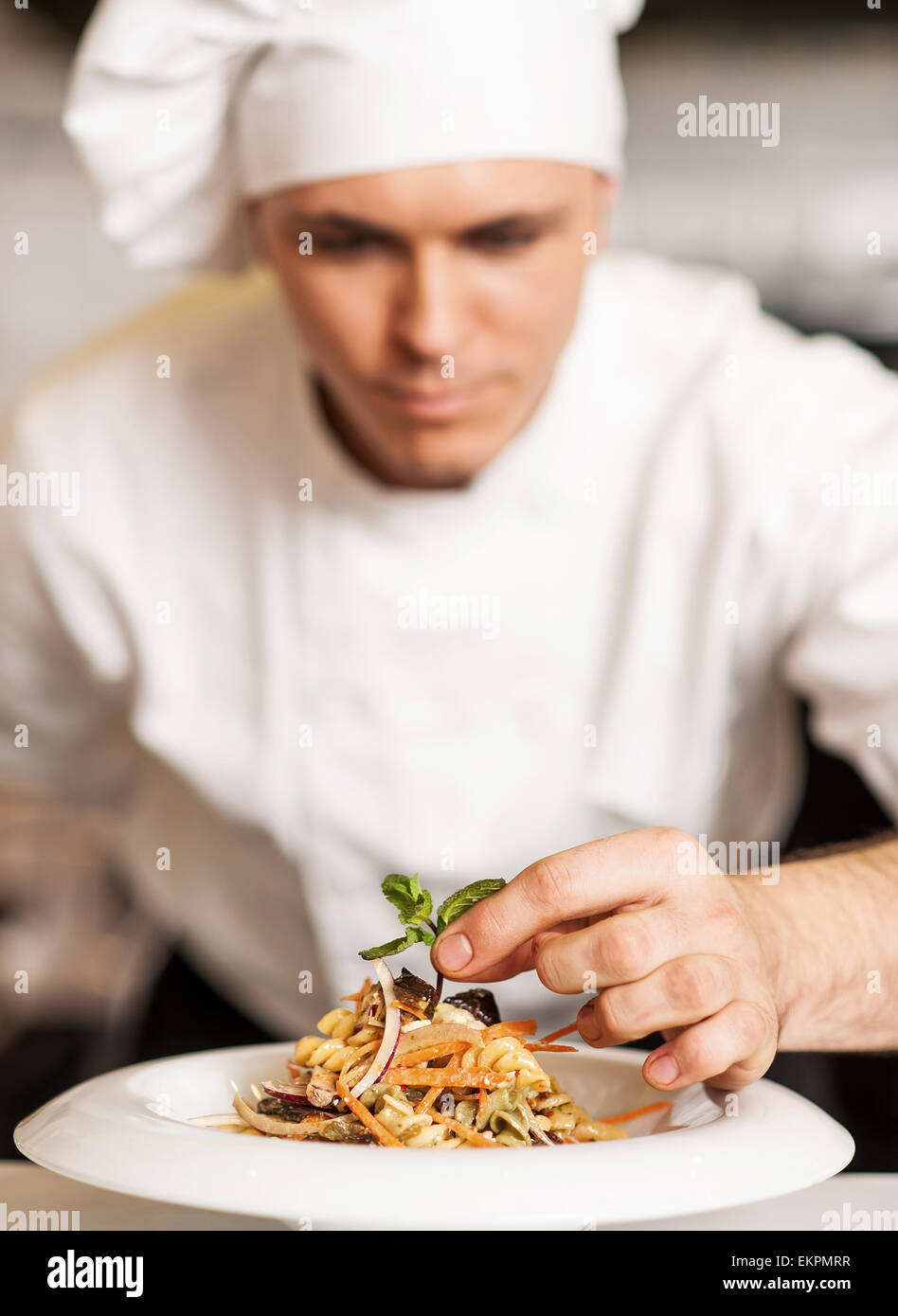 Chef decorating pasta salad with herbal leaves Stock Photo - Alamy