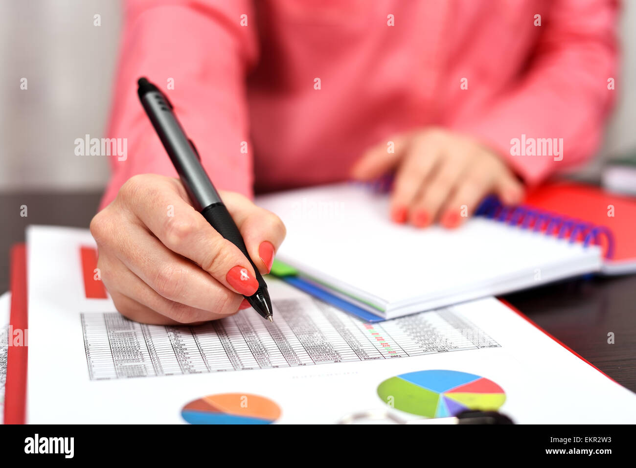 woman with pen checks the financial report Stock Photo - Alamy