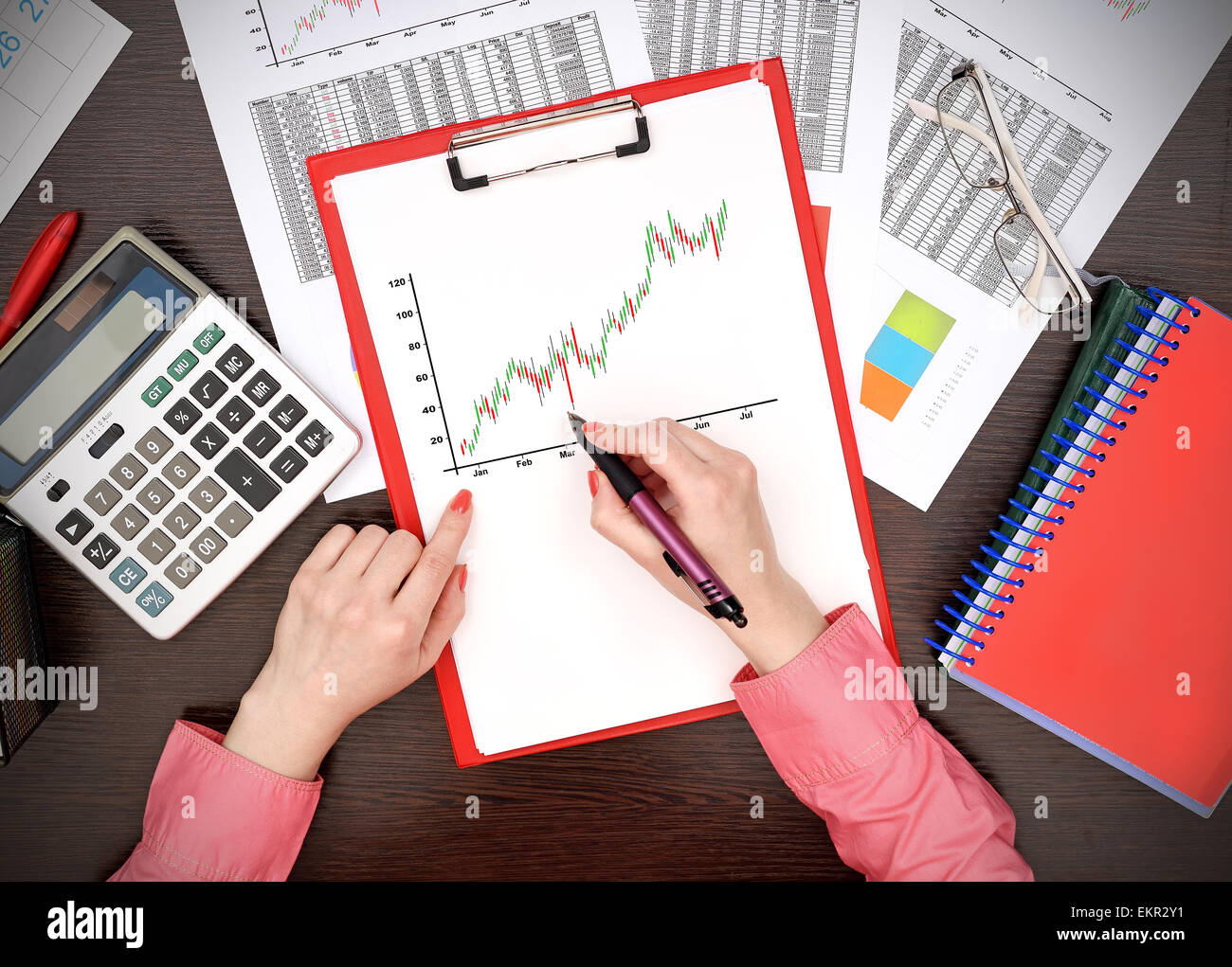 woman drawing stock chart on clipboard sitting in office Stock Photo ...