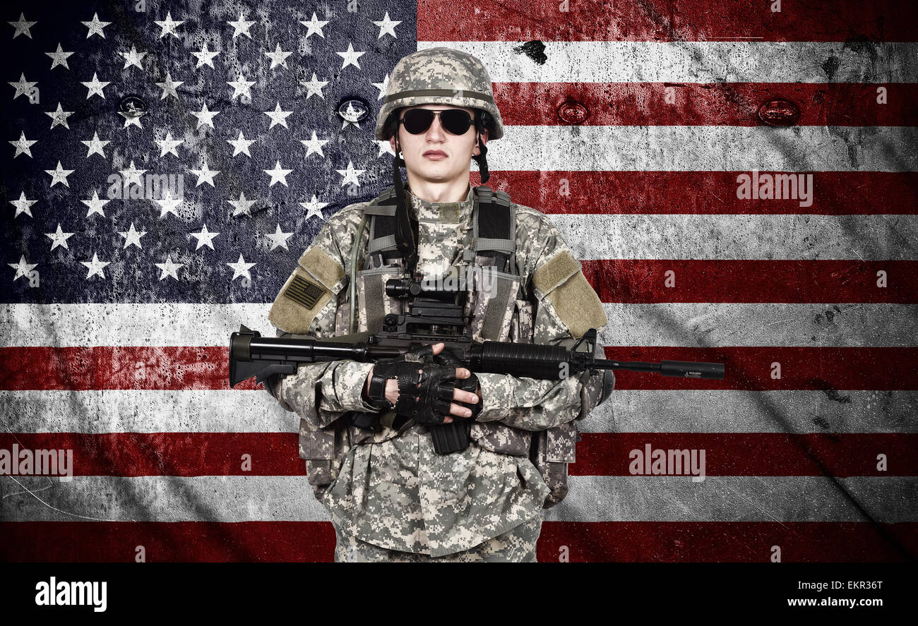 US soldier holding rifle on a american flag background Stock Photo - Alamy