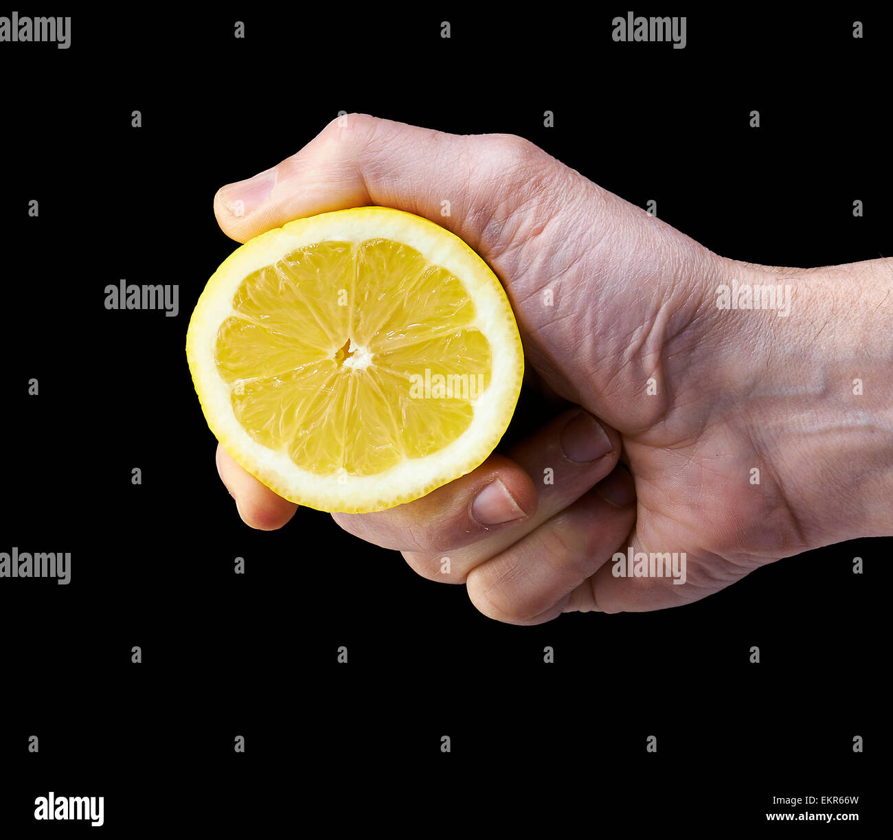 Man's hand squeezing half of lemon on black background Stock Photo - Alamy
