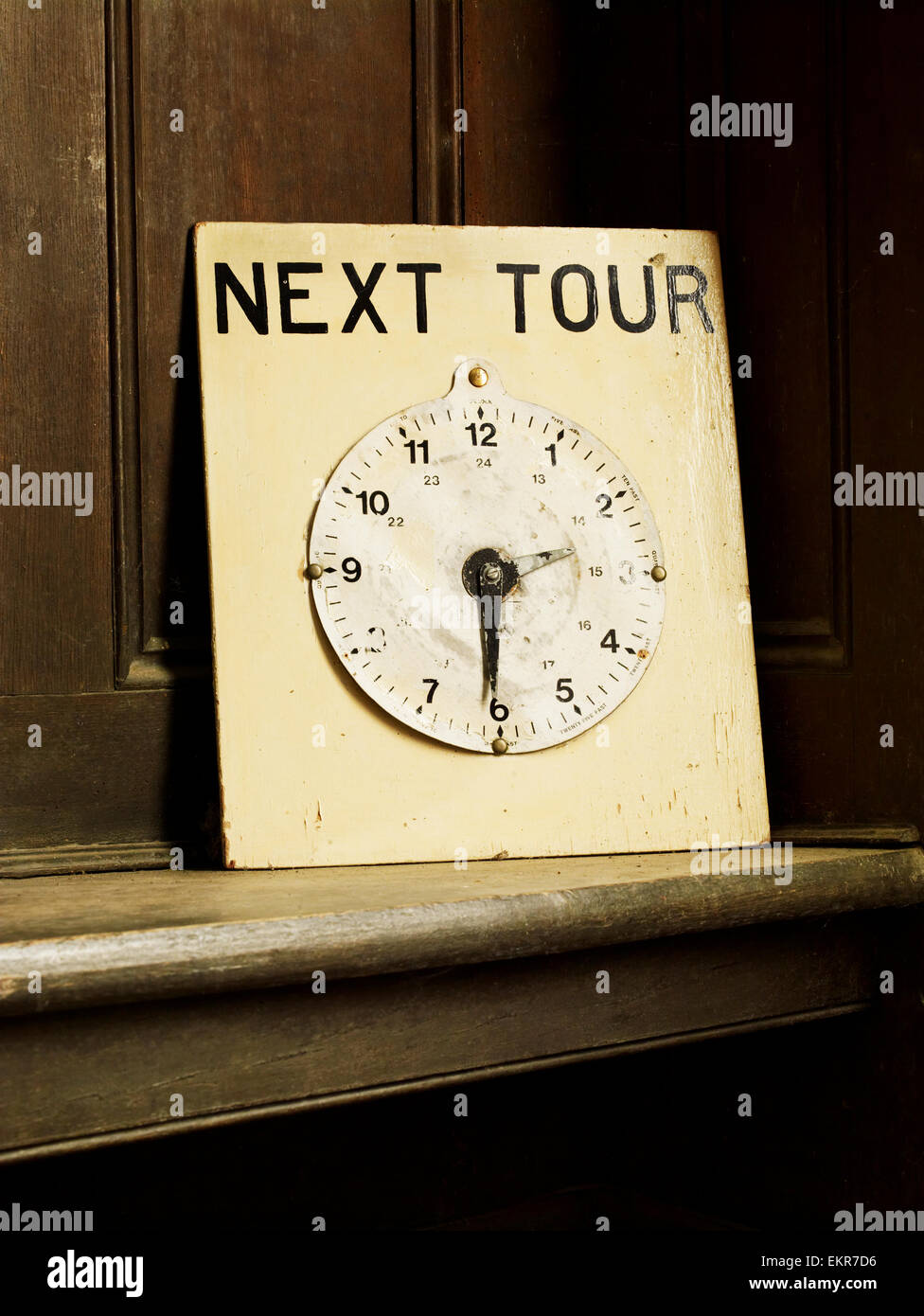 A clock face on a board with hands set to the time 2.30pm indicating ...