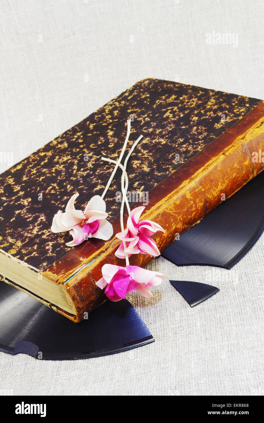 Old book and artificial flowers on a broken gramophone record Stock ...