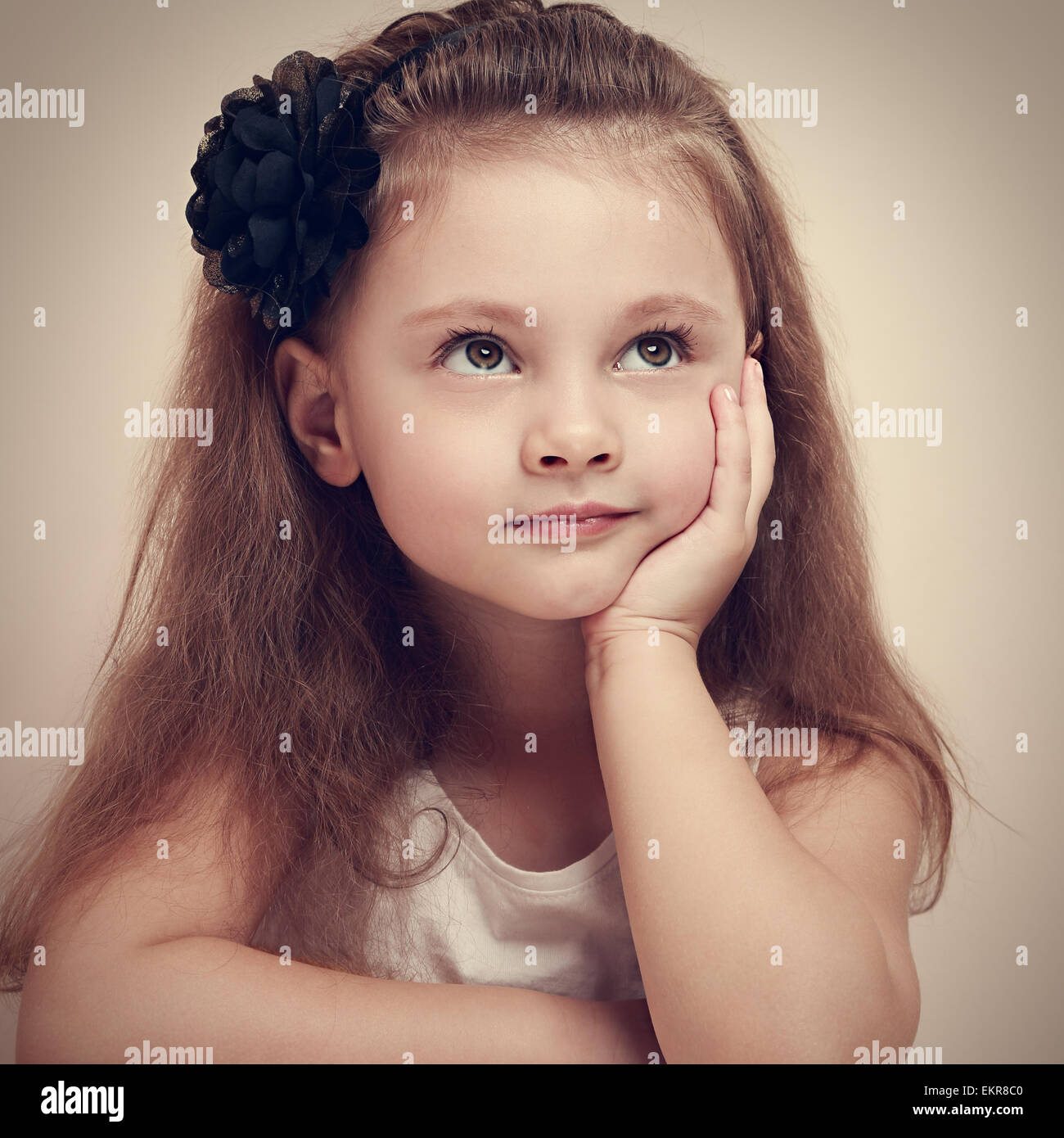 Beautiful small kid model with pretty eyes dreaming about. Closeup ...