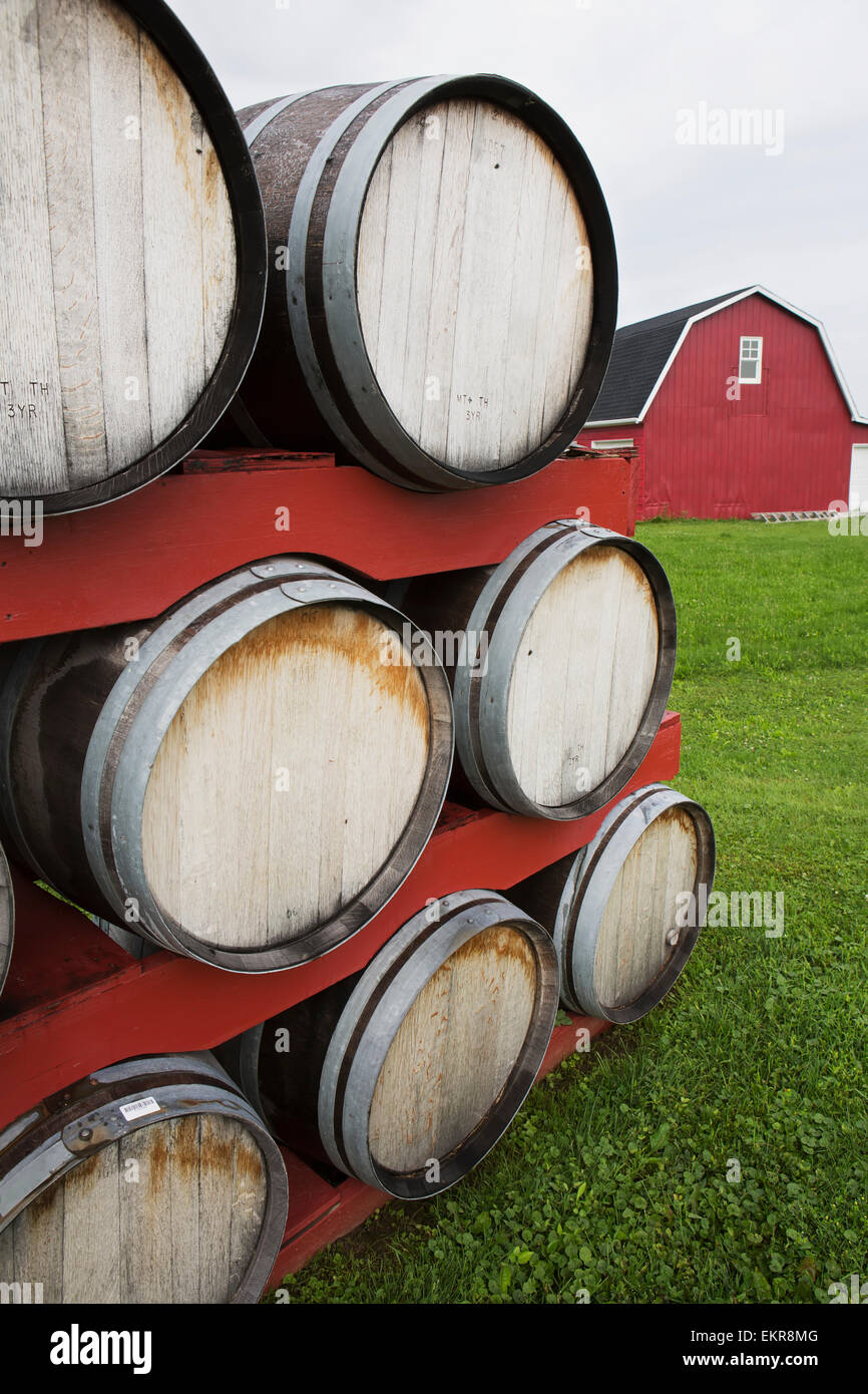 Stacks of wooden barrels with a red barn in the background; Niagara on ...