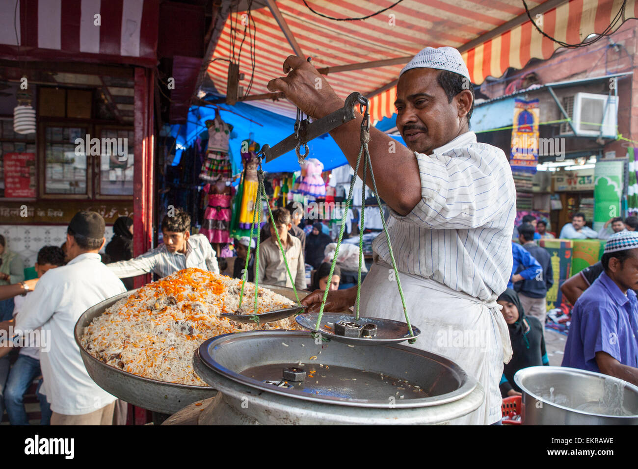 A Muslim cook weighing a portion of rice Biryani at a food stall in the ...