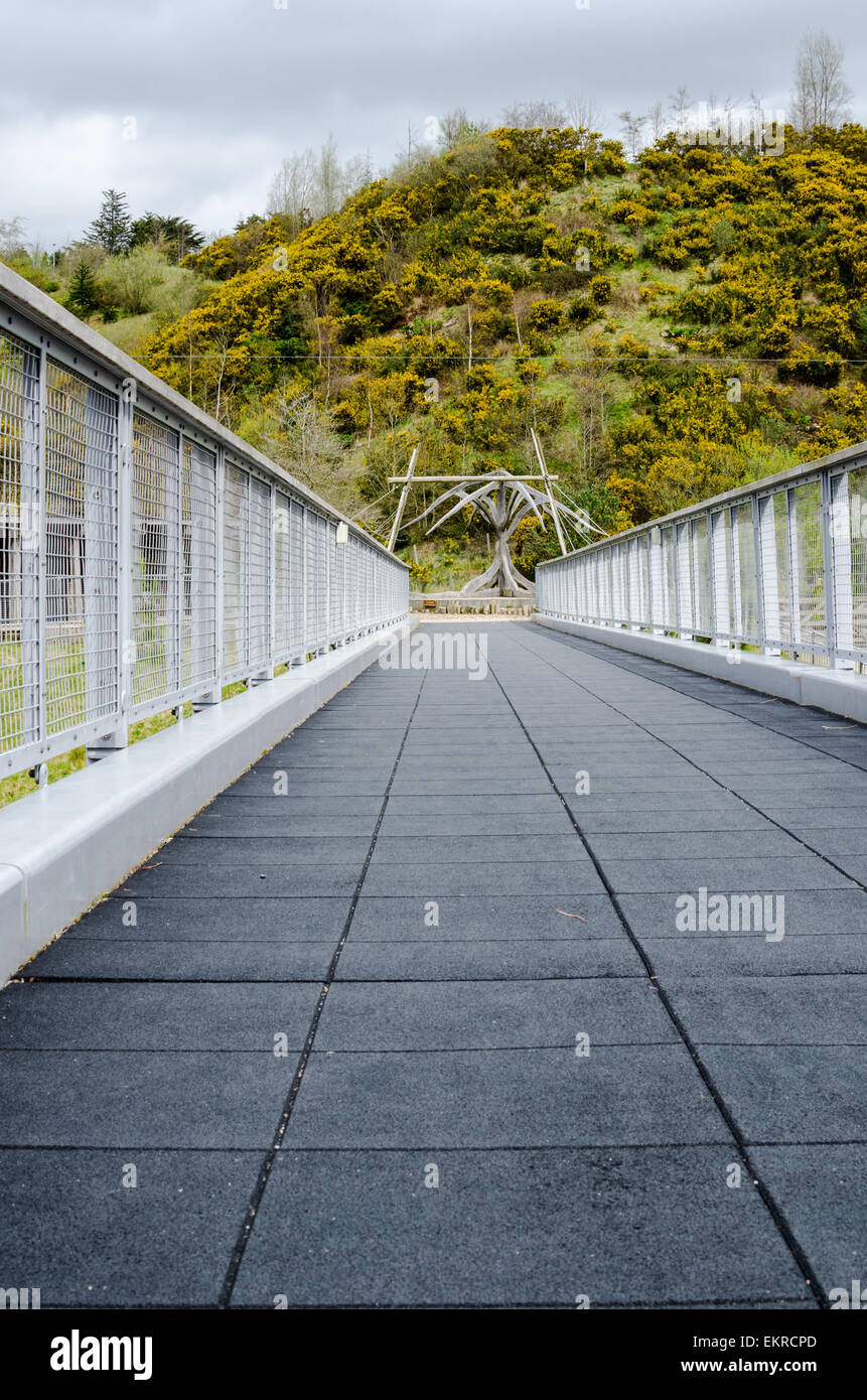 Vertical image of an empty foot bridge with diminishing lines and tree ...