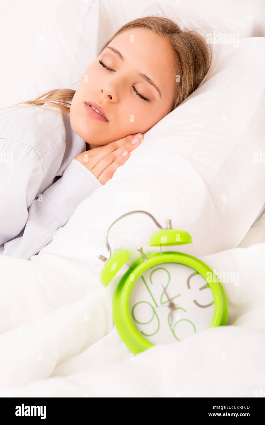 Beautiful woman sleeping with alarmclock on the bed Stock Photo - Alamy