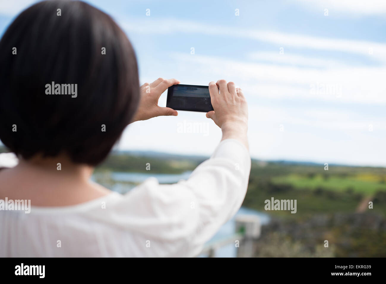 Back view of a woman taking photograph with a smart phone camera Stock ...