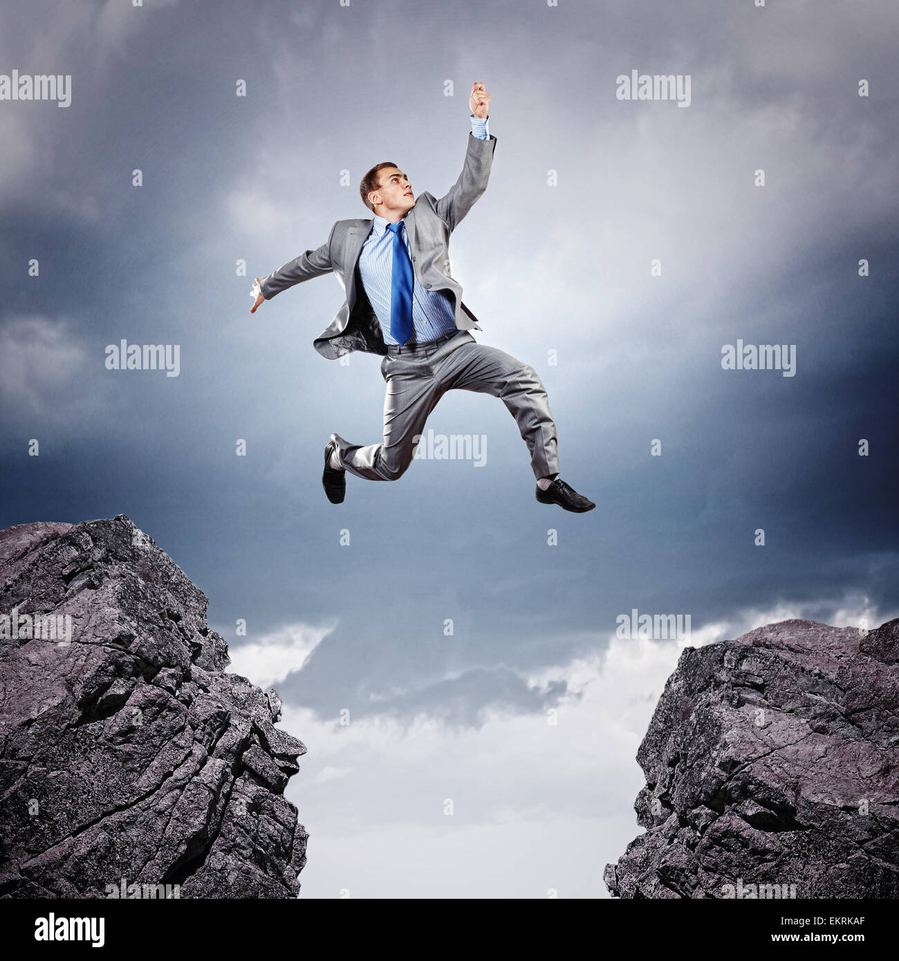 Businessman jumping over gap Stock Photo - Alamy