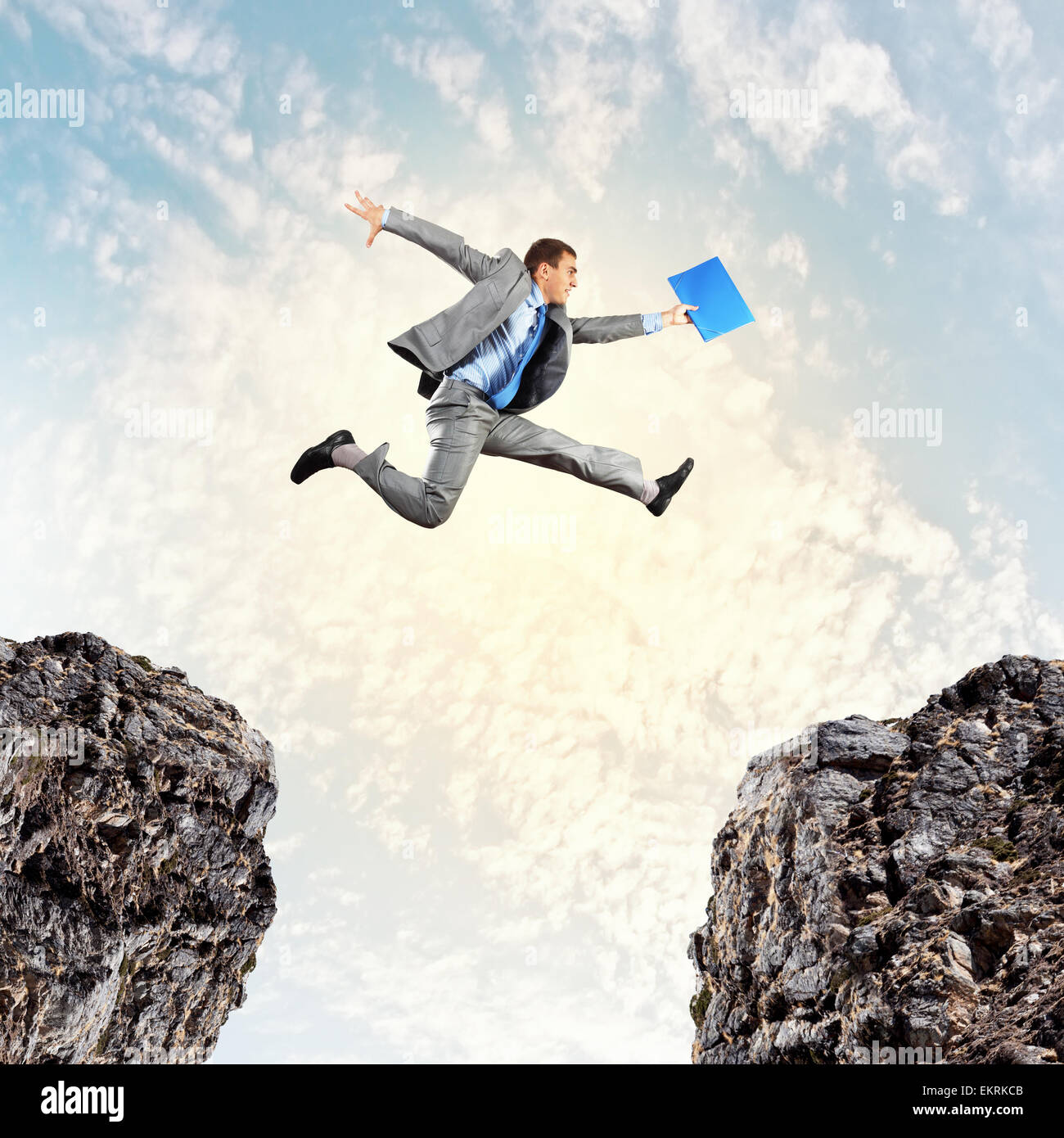 Businessman jumping over gap Stock Photo - Alamy