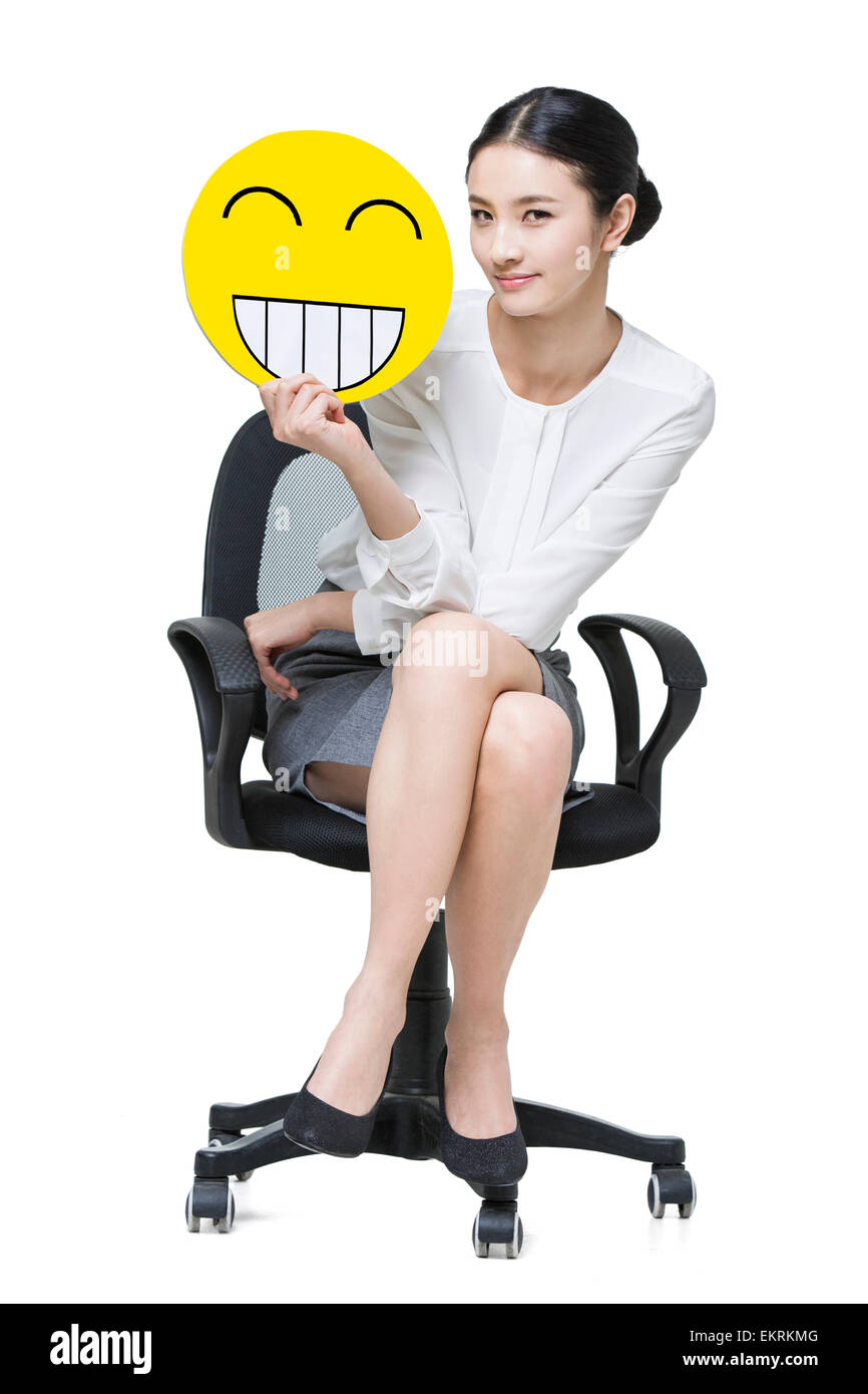 Young businesswoman holding a happy emoticon face Stock Photo - Alamy