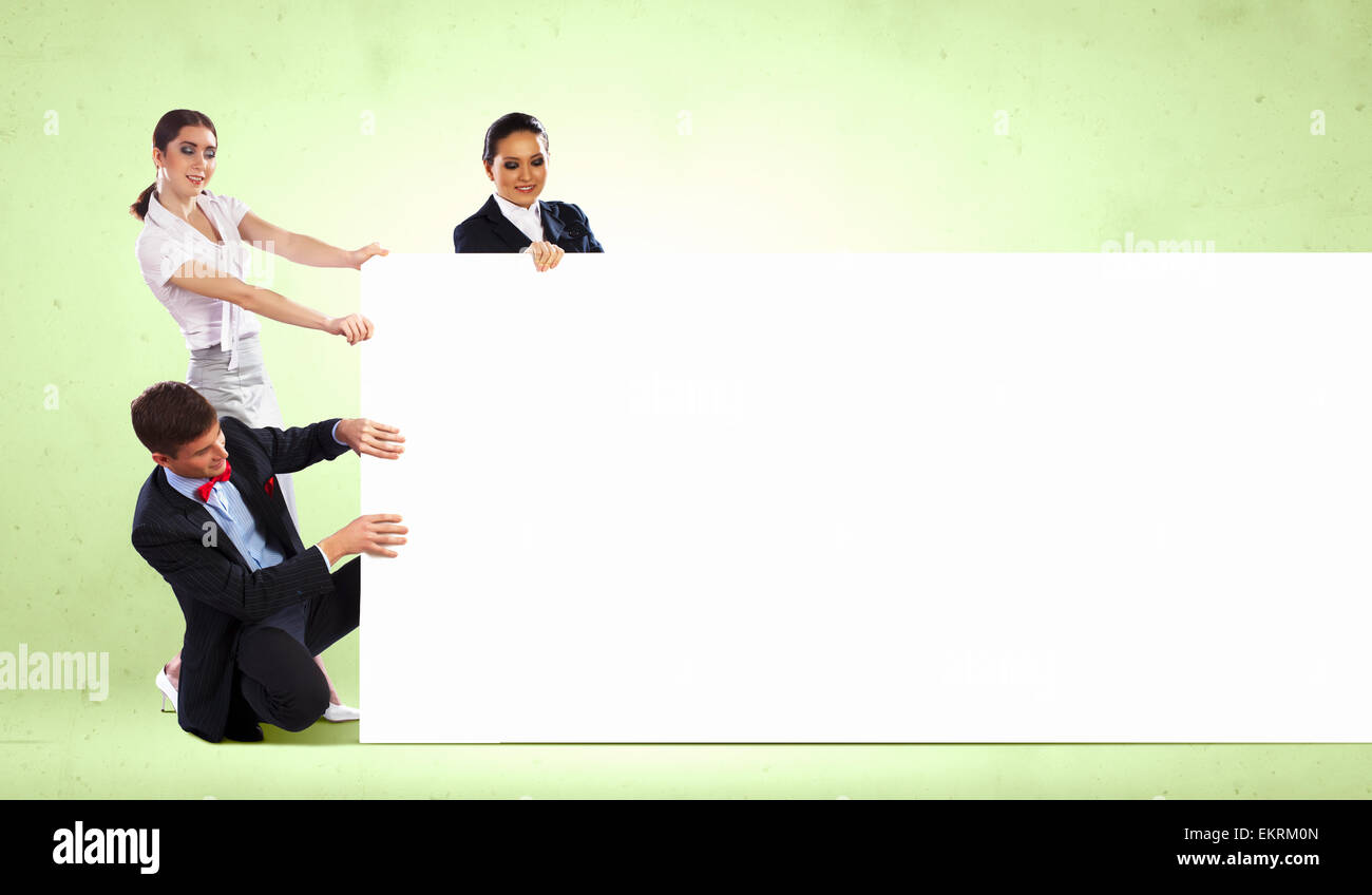 Three young people holding banner Stock Photo - Alamy