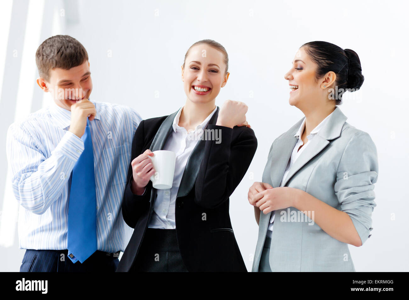 Three young business people laughing Stock Photo - Alamy